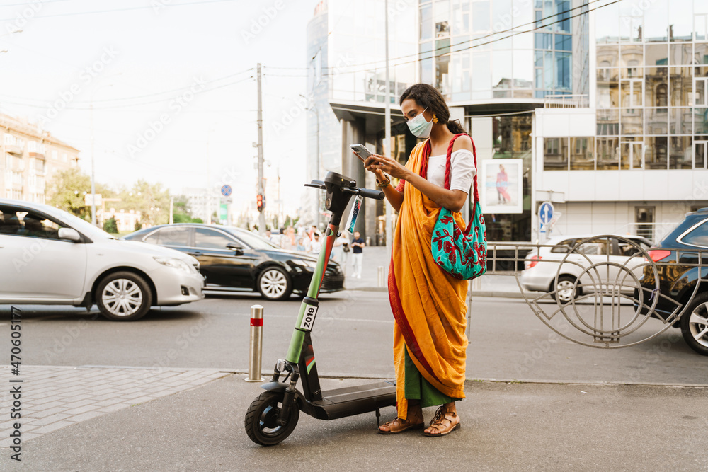 Young indian woman using cellphone while standing outdoors Stock Photo ...