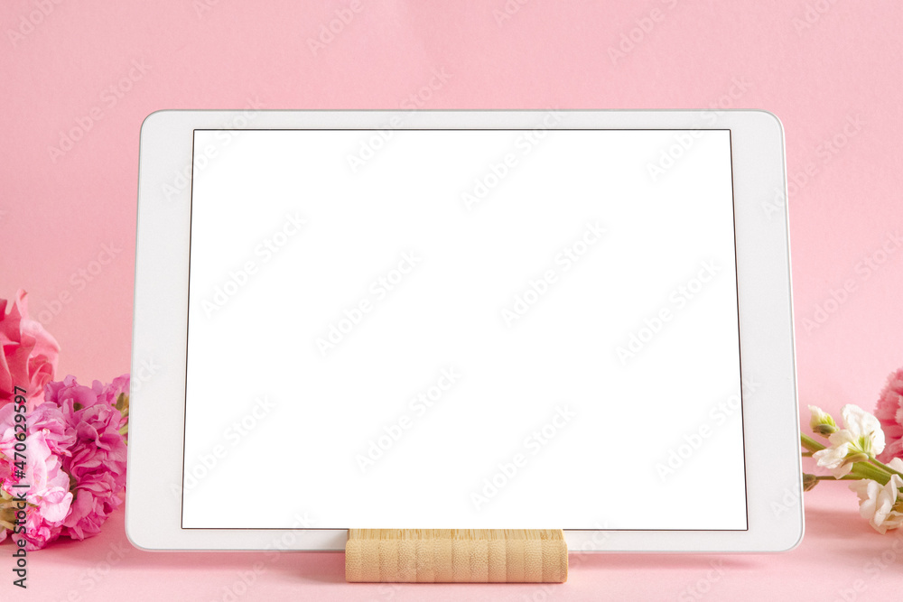iPad pro tablet with white screen on pink color background flowers ...