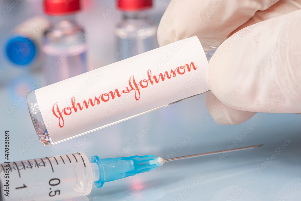 A vaccination syringe and a glass ampoule with a clear liquid on a blue ...