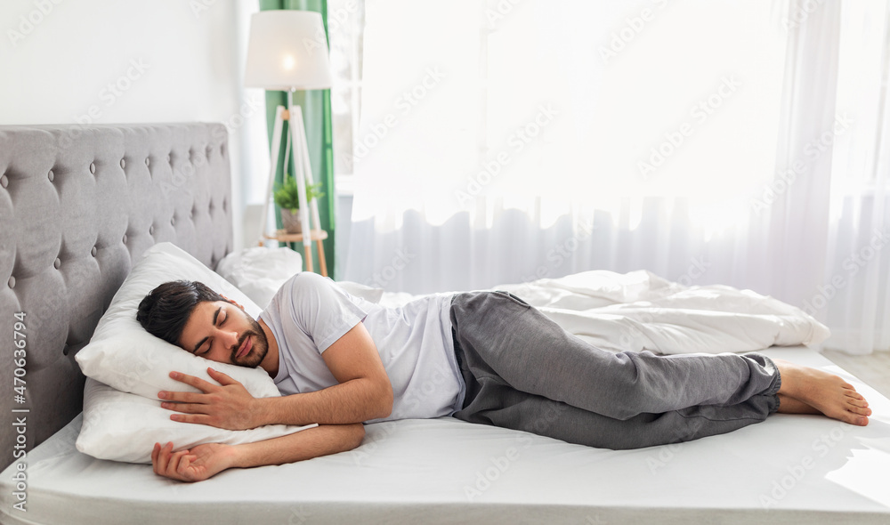 Full body length of calm arab man sleeping well on the side, resting ...