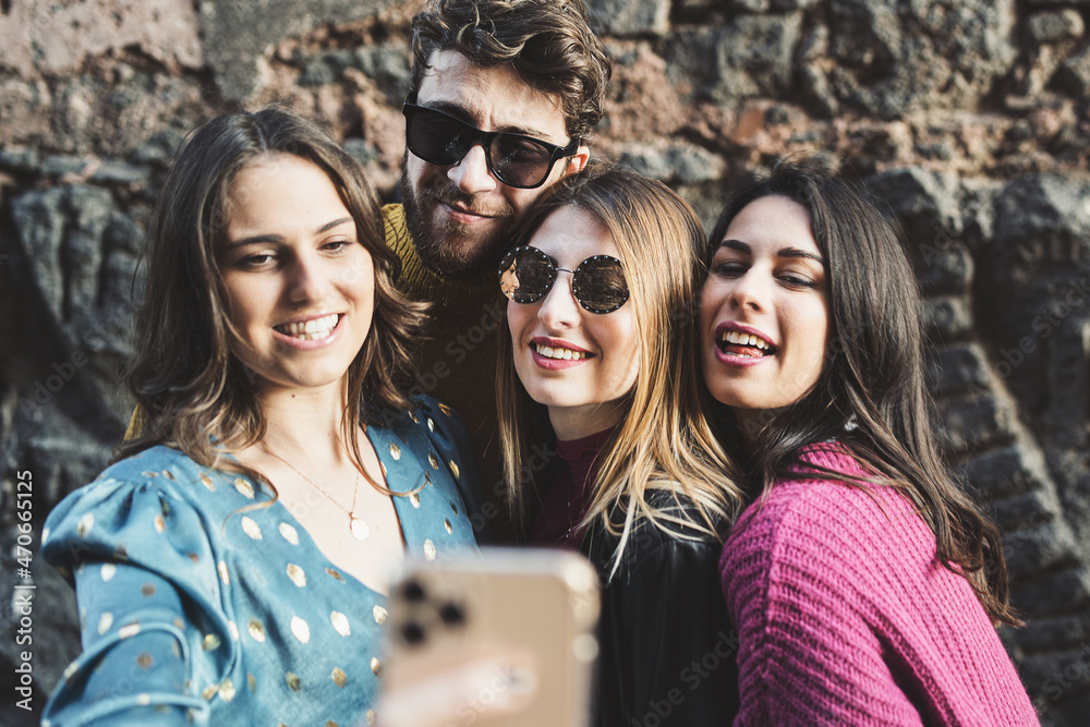 Group of happy friends using mobile phone for a selfie - gen z cheerful ...