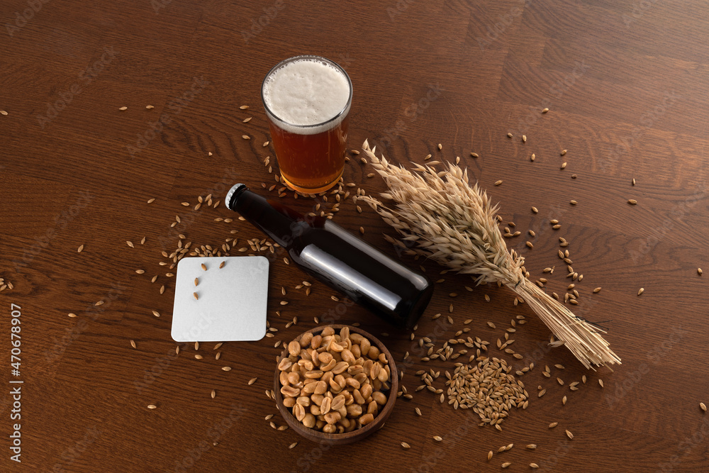 Blank beer bottle and glass with beer, peanuts bowl, wheat, malts, beer ...