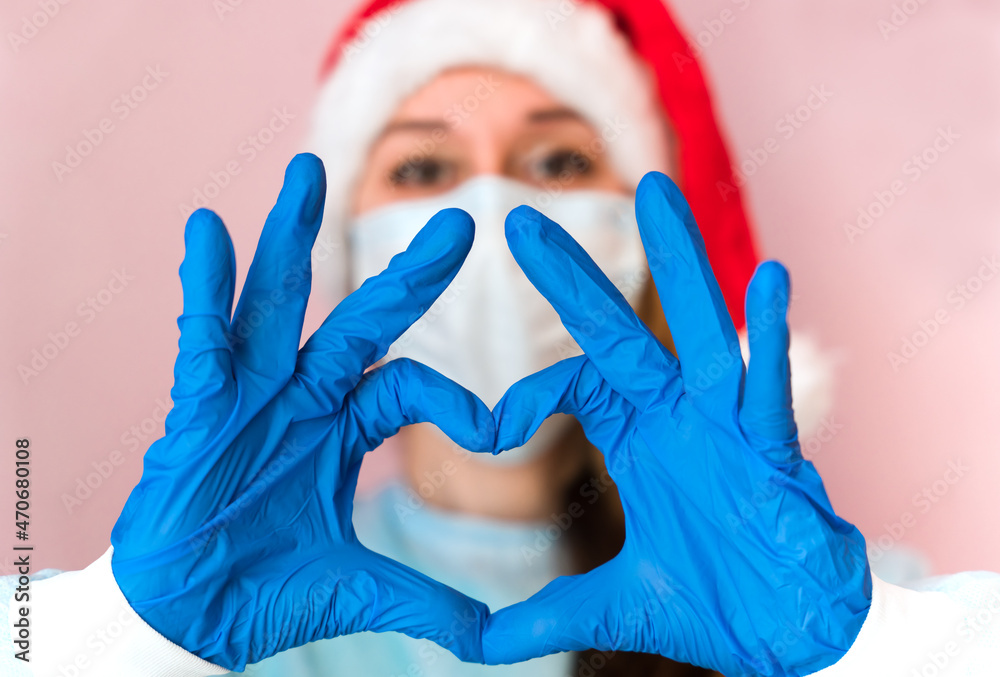 Doctor or nurse in a santa hat, medical mask and in medical gloves ...
