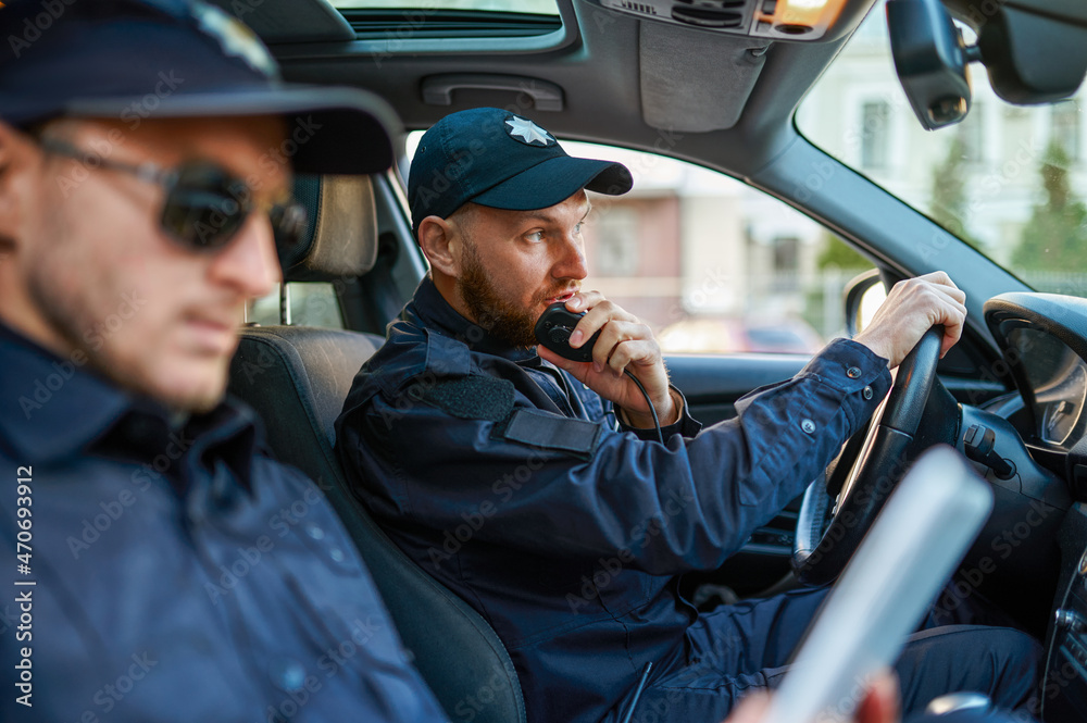 Two male police officers in uniform poses in car Stock Photo | Adobe Stock