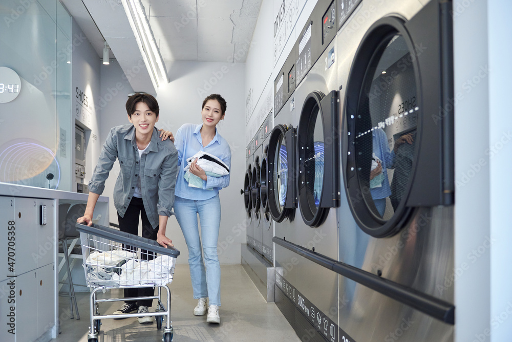 셀프 세탁실을 배경으로 대학생 커플 또는 신혼부부가 함께 또는 혼자 세탁기 또는 건조기 작동과 빨래 정리하는 모습 아시아 한국