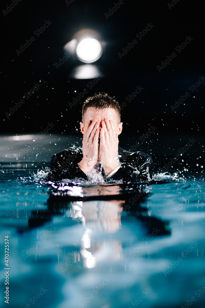 Man in black suite swimming in a pool. business man having fun in a ...