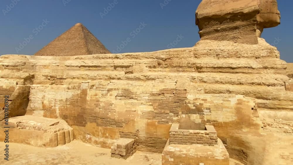 Side view of Great Sphinx of Giza, Pyramid of Cheops in background ...