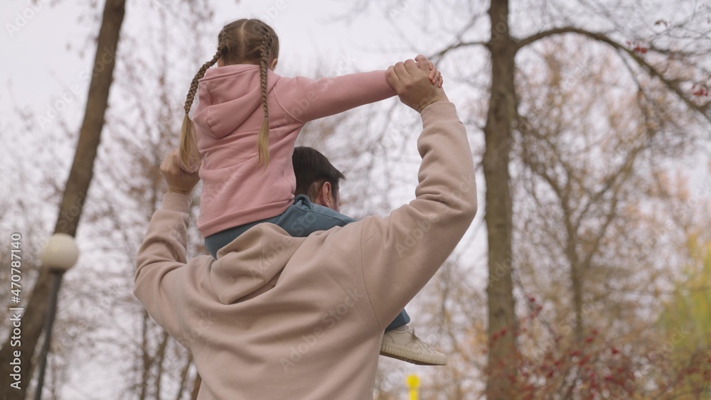 child sits his father's neck, dad carries kid on his shoulders in an ...