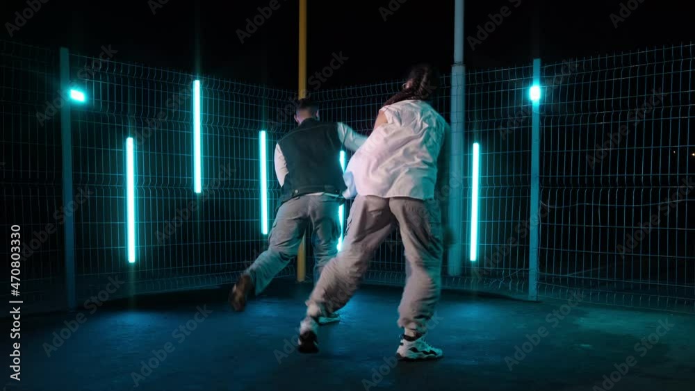 Duet of dancers performing afro dance at night with lightstands at ...