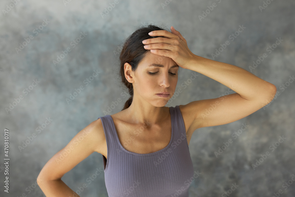 Exhausted, frustrated, desperate female of 30s holding her forehead ...