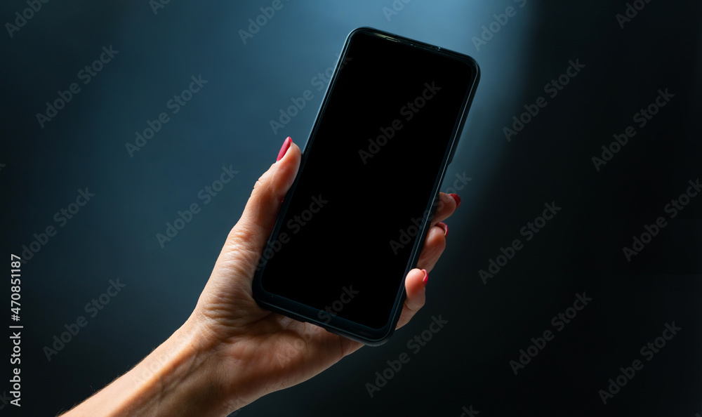 Hand holding smartphone with black copy space. Female person with ...