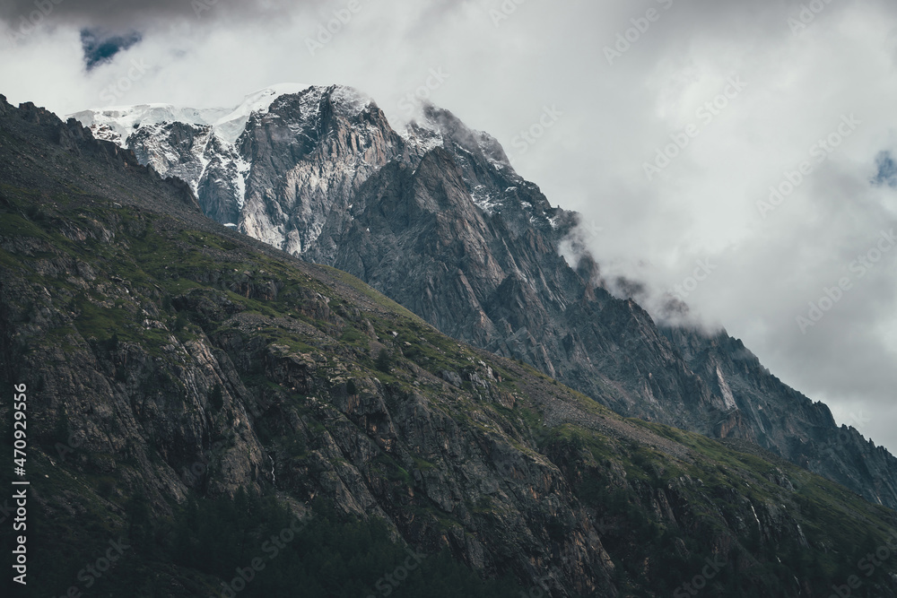 Dark atmospheric surreal landscape with dark rocky mountain top in low ...