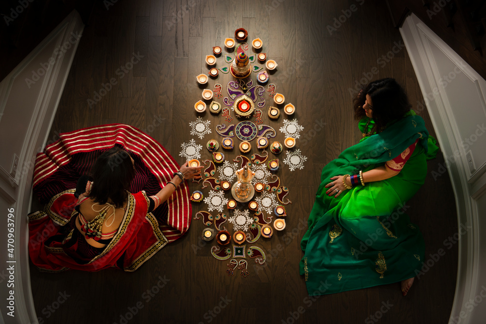 Indian Women doing a rangoli for Diwali Stock Photo | Adobe Stock