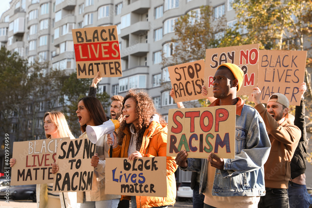 Protesters demonstrating different anti racism slogans outdoors. People ...