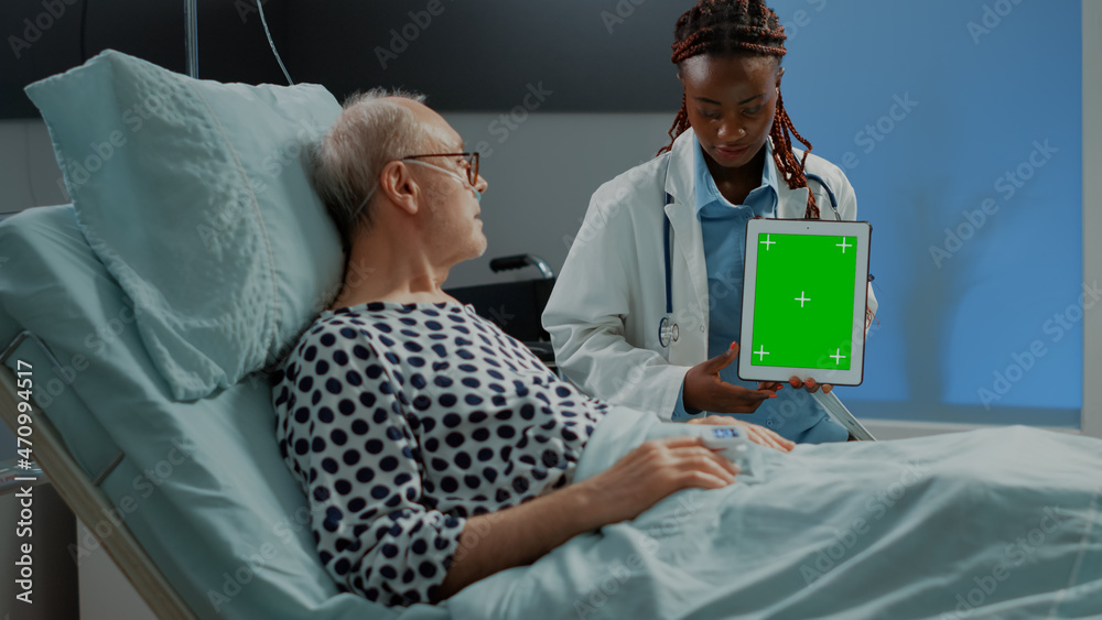 Analysis doctor showing tablet with green screen to patient in hospital ...