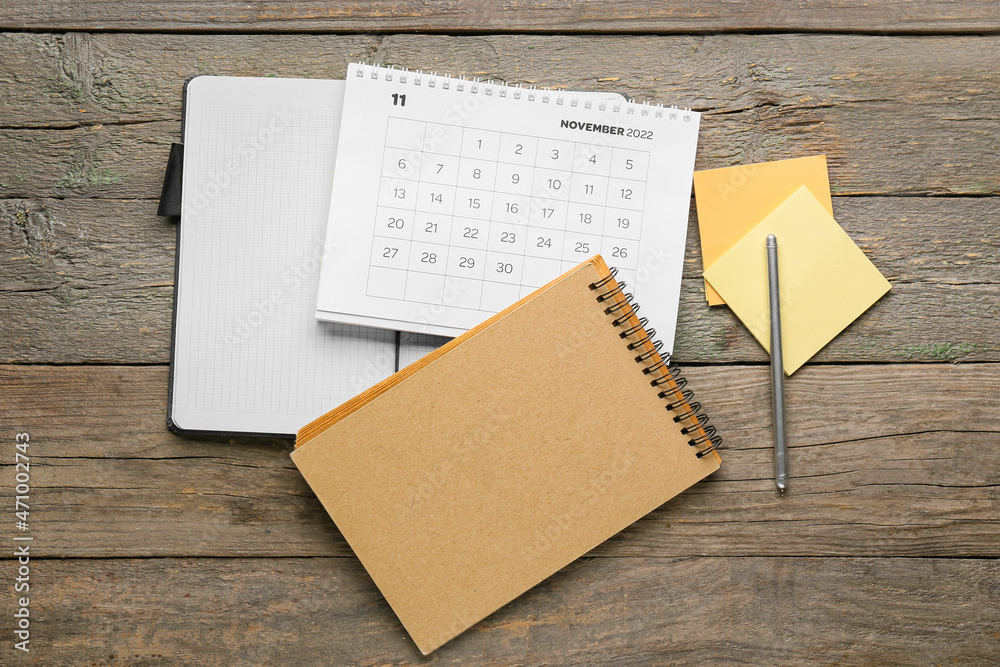 Paper calendar with stationery and notebooks on wooden background Stock ...