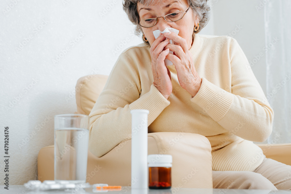 Senior sick woman with virus symptoms sneezing into napkin, close-up ...