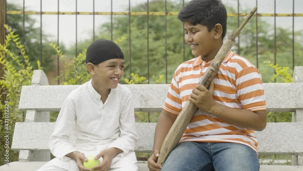 Happy indian multiethnic children talking about cricket with bat and ...