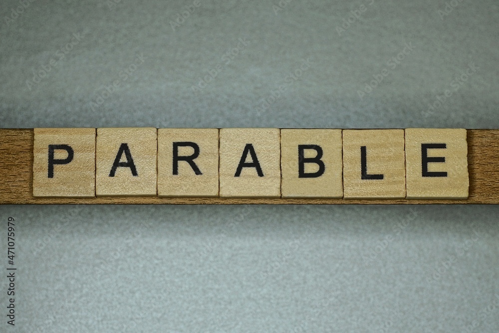 text the word parable from gray wooden small letters on an gray table ...