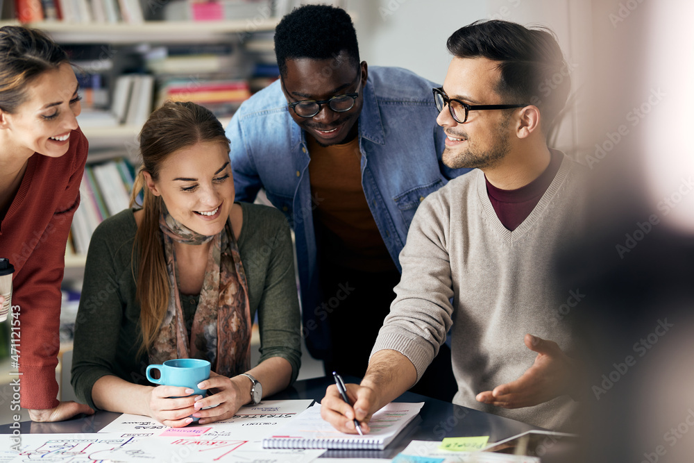 Foto de Happy creative team writes business ideas while brainstorming ...