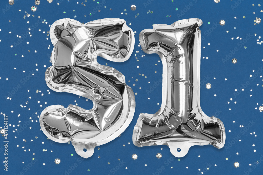 Silver foil balloon number, digit fifty one on a blue background with ...