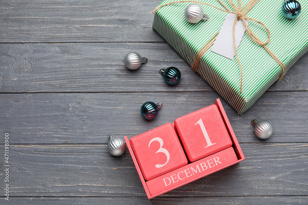 Calendar with date of December 31, decorations and gift boxes on grey ...