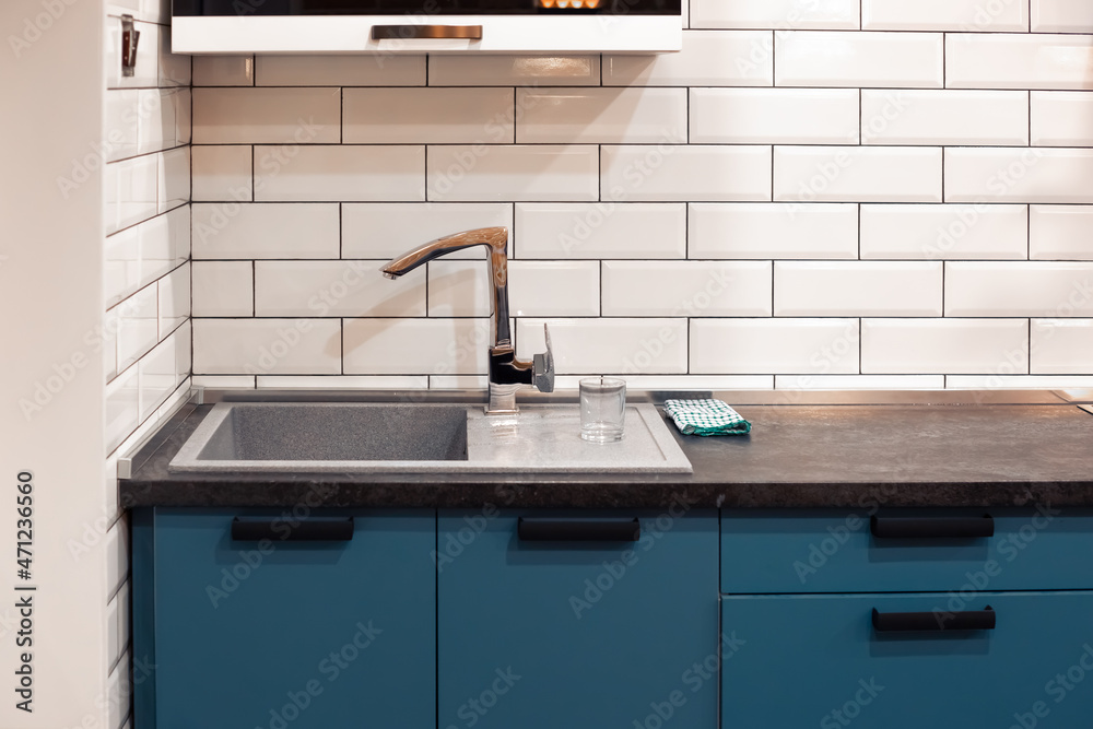Kitchen design with white brick tiles and a dark countertop with a deep ...