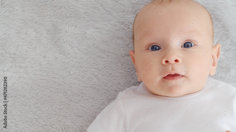 Child's face of a Happy newborn baby looking to camera. Healthy newborn ...