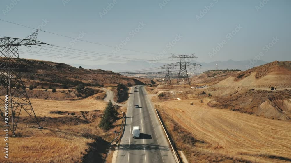 Aerial high voltage power lines over highway road. Electric power ...