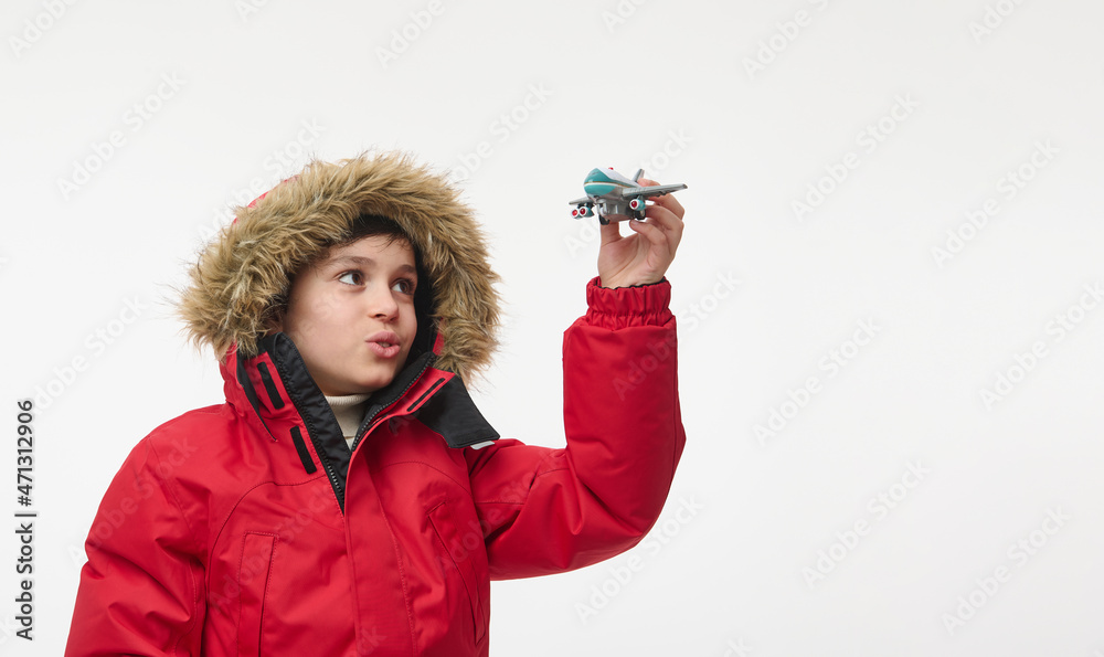 Close-up portrait of an adorable school boy playing with an airplane ...