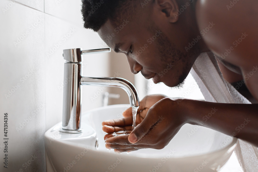 African American Man Washing Face Standing Shirtless In Bathroom Stock ...