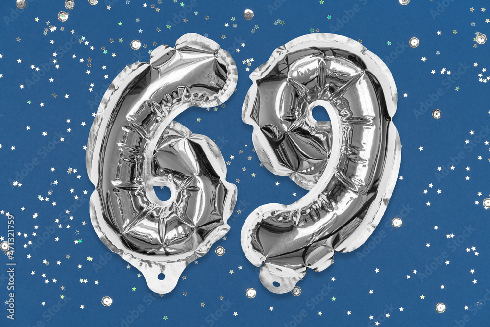 Silver foil balloon number, digit sixty nine on a blue background with ...