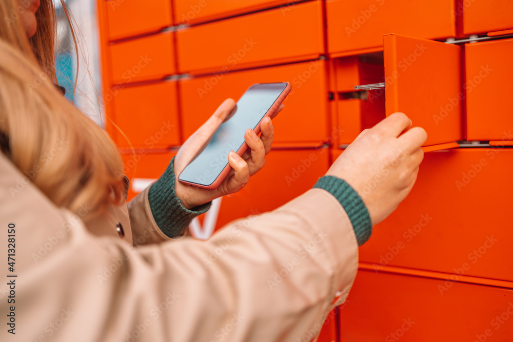 Woman client using automated self service post terminal machine or ...