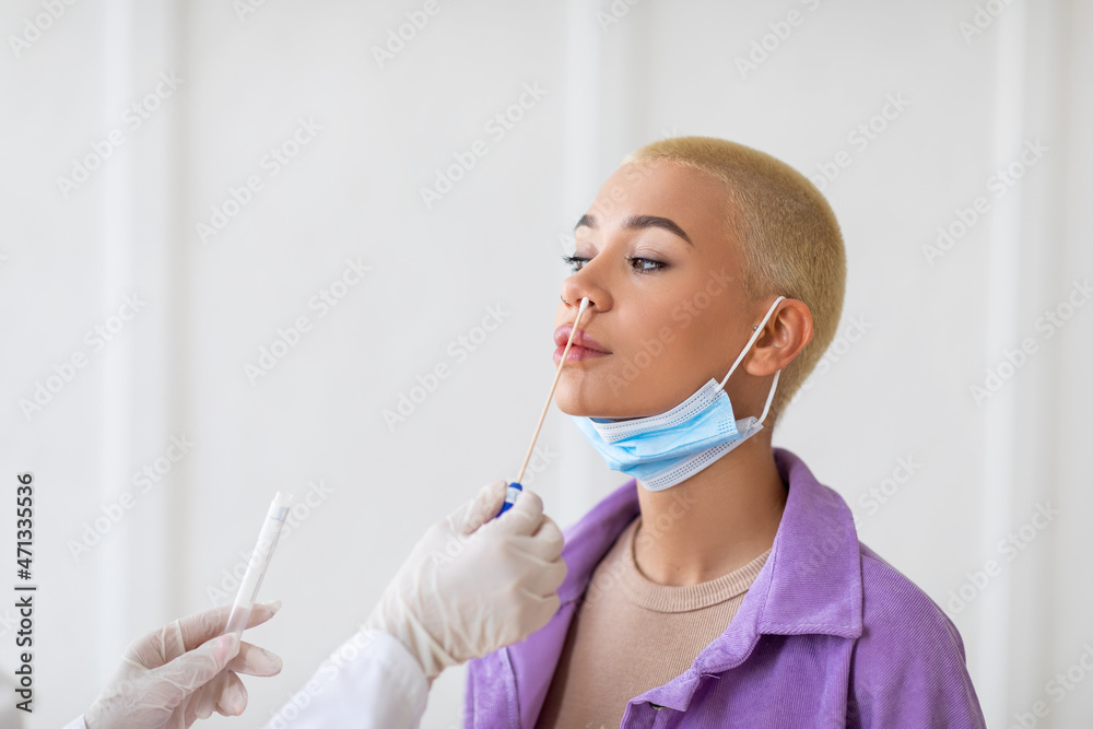 Doctor making covid-19 PCR test for female patient, free space. Young ...