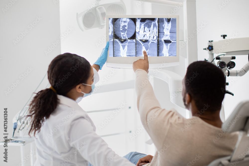 Black Female Stomatologist Showing Teeth Xray Picture On Digital ...