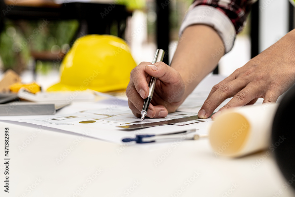 Architect uses a ruler to measure the blueprints of the houses he ...