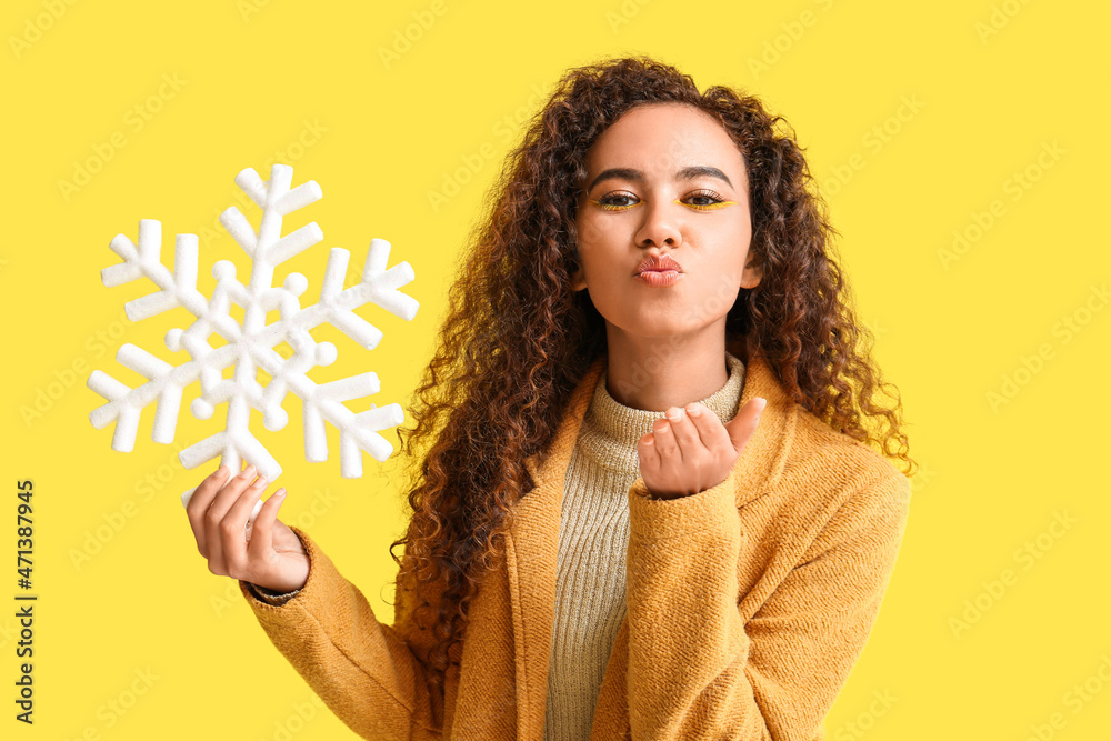 Beautiful African-American woman with big snowflake blowing kiss on ...