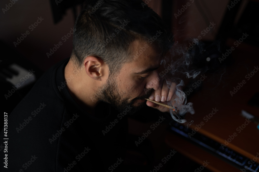 biracial hipster smoking weed with splif in hand with a trendy haircut ...