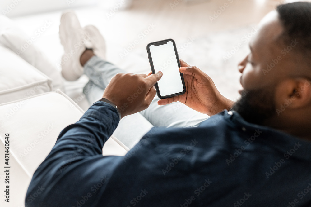 Back view over shoulder of smiling black guy at smartphone with empty ...