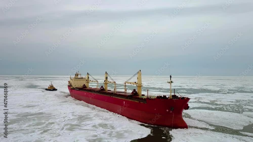 Aerial above epic huge steel icebreaker breaks ice by bow of ship and ...