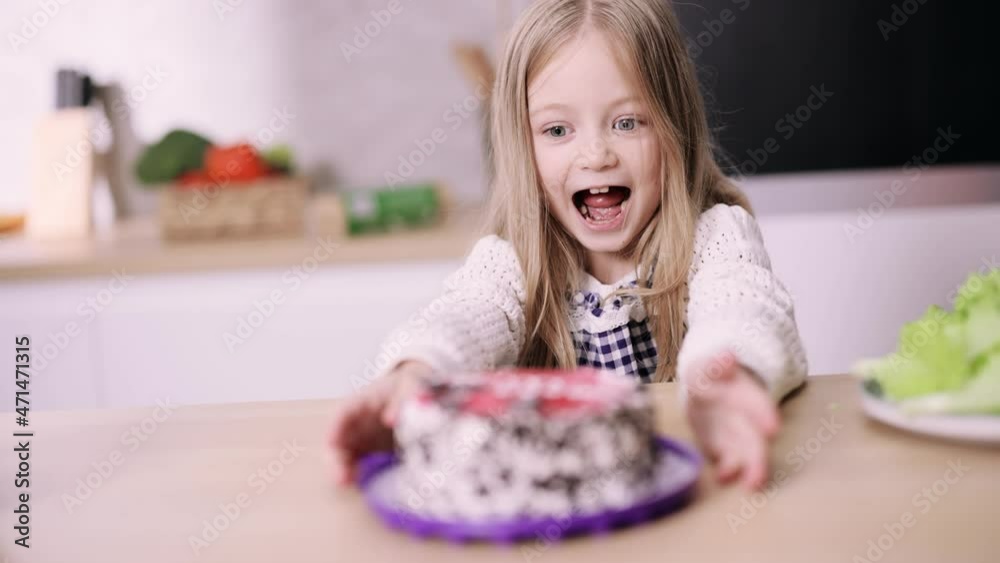 Funny little girl appearing over table looking on cake with excitement ...