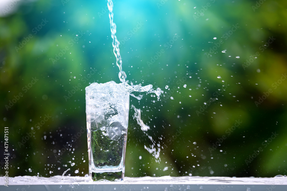 Drink Water Pouring In To Glass Over Sunlight And Natural Green drink-water-pouring-in-to-glass-over-sunlight-and-natural-green