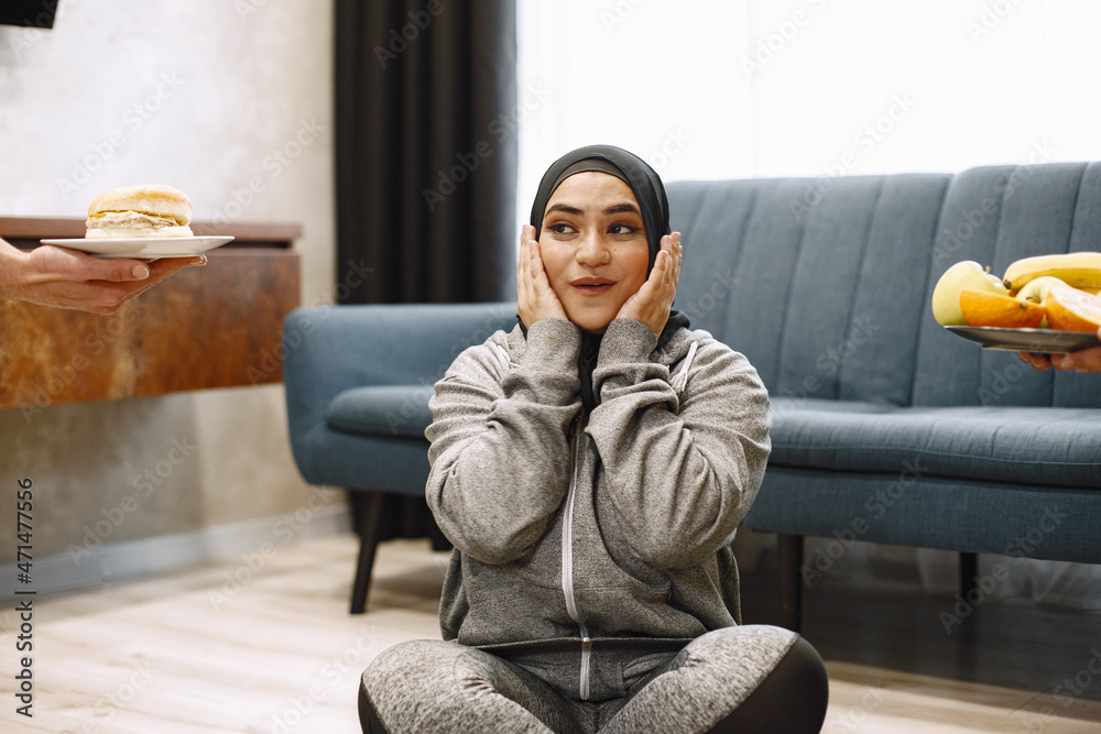 Arab woman choosing between healthy and unhealthy eating. Stock Photo ...