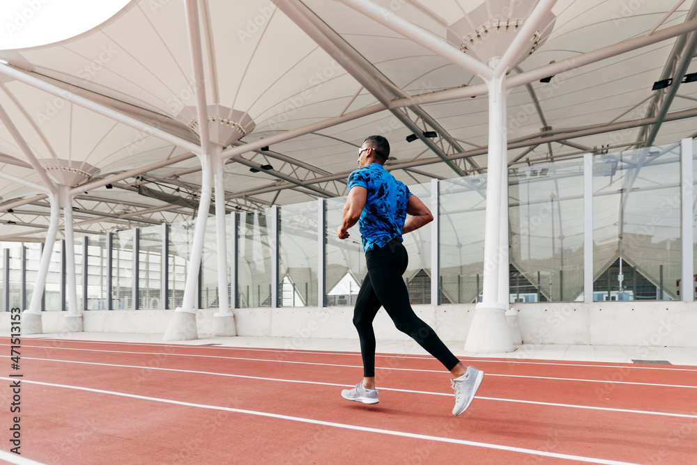 Athletic man running on the running track Stock Photo | Adobe Stock