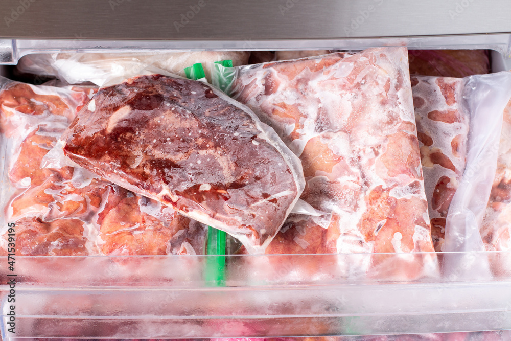 Frozen meat and meat frozen products in plastic package in the freezer ...