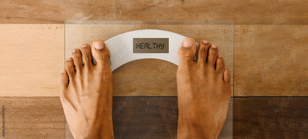 pair of feet on a weight scale, healthy concept. Stock Photo | Adobe Stock
