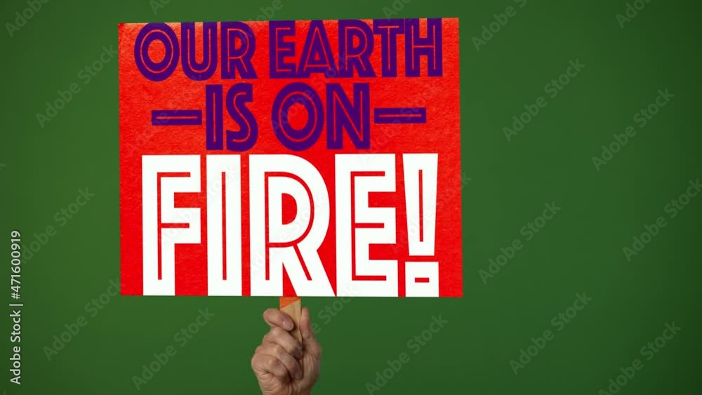 Arm holding a sign that says OUR EARTH IS ON FIRE on a green screen ...