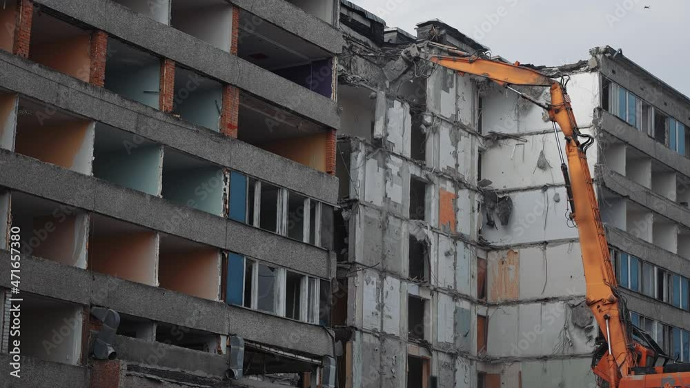 Excavator claw tearing off the big block in the condemned building ...