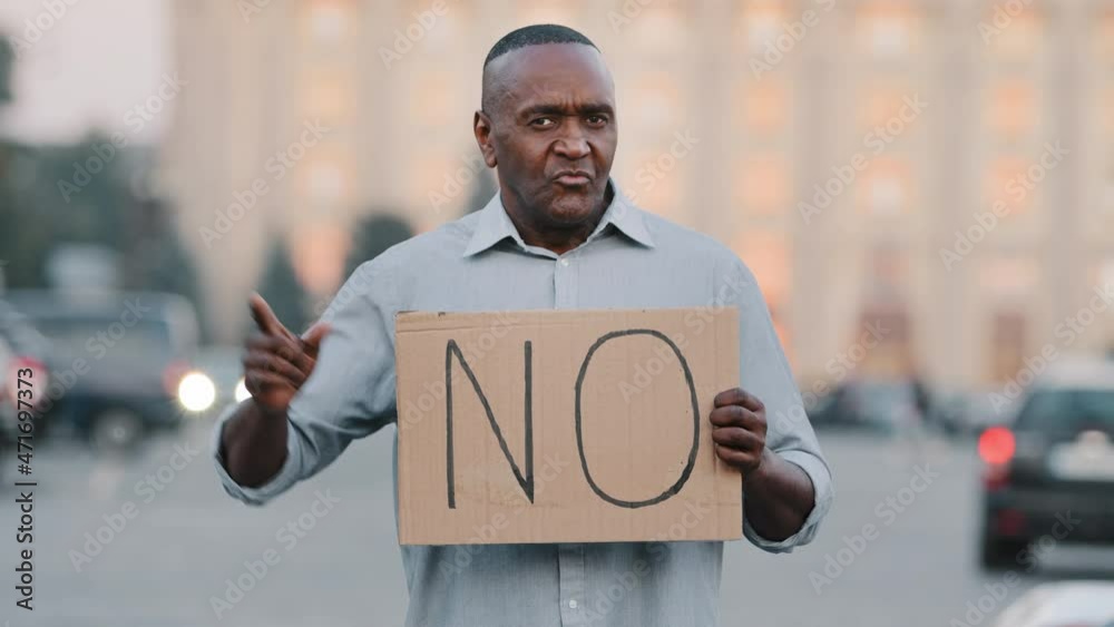 Black immigrant person holding cardboard slogan banner with text no ...