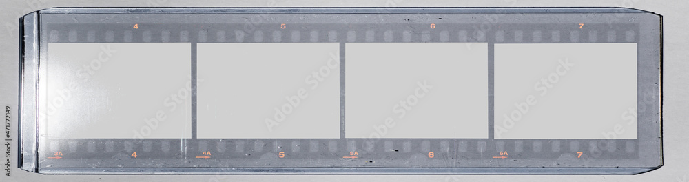 long 35mm dia film strip with empty frames behind transparent plastic ...